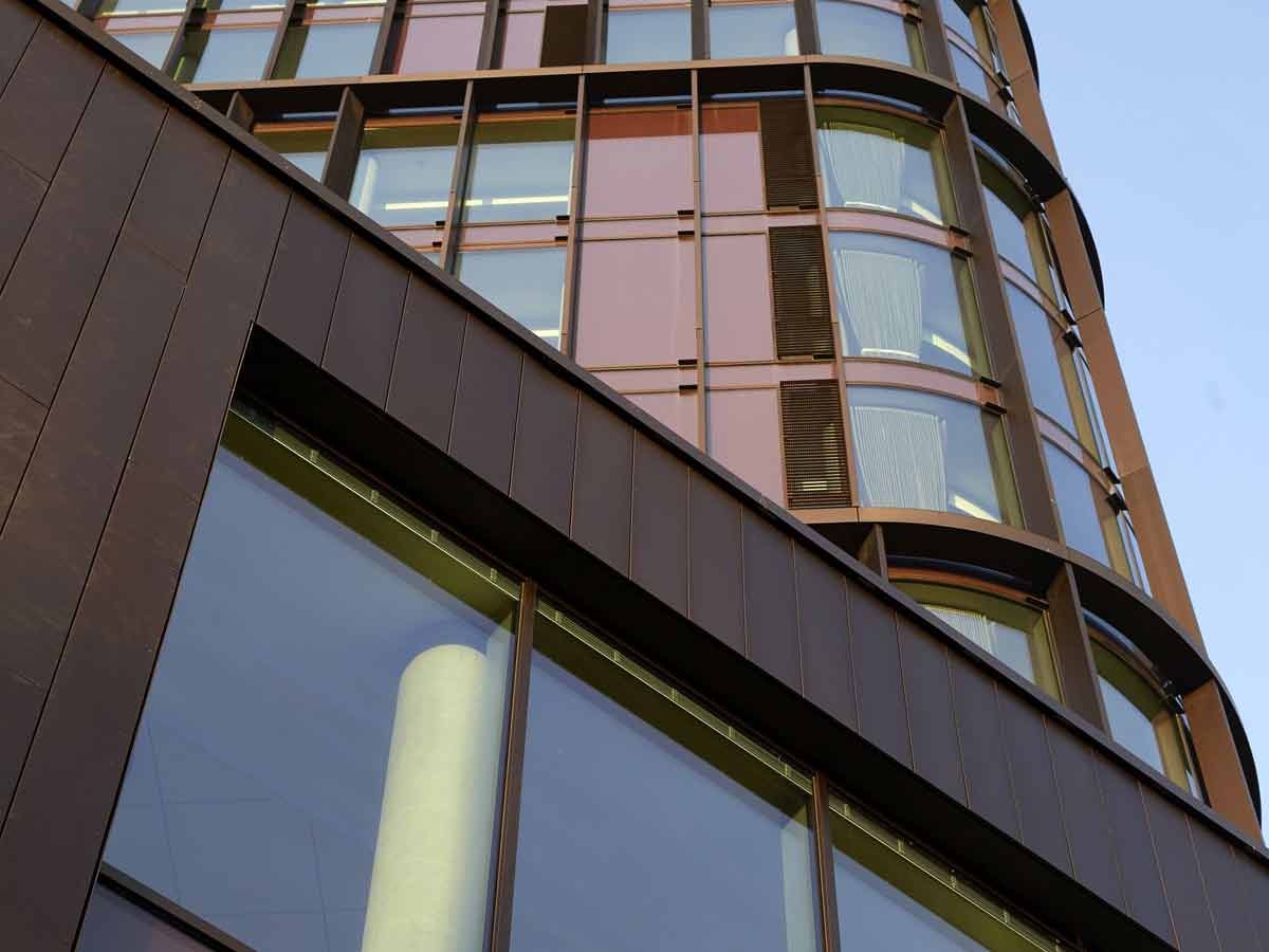 Kupferfassade mit gebogenem Glas und integriertem Sonnenschutz | Haustec